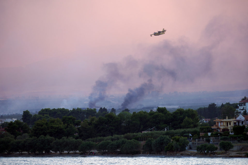 News Wrap: Wildfires trigger explosions in Greece as flames reach ...